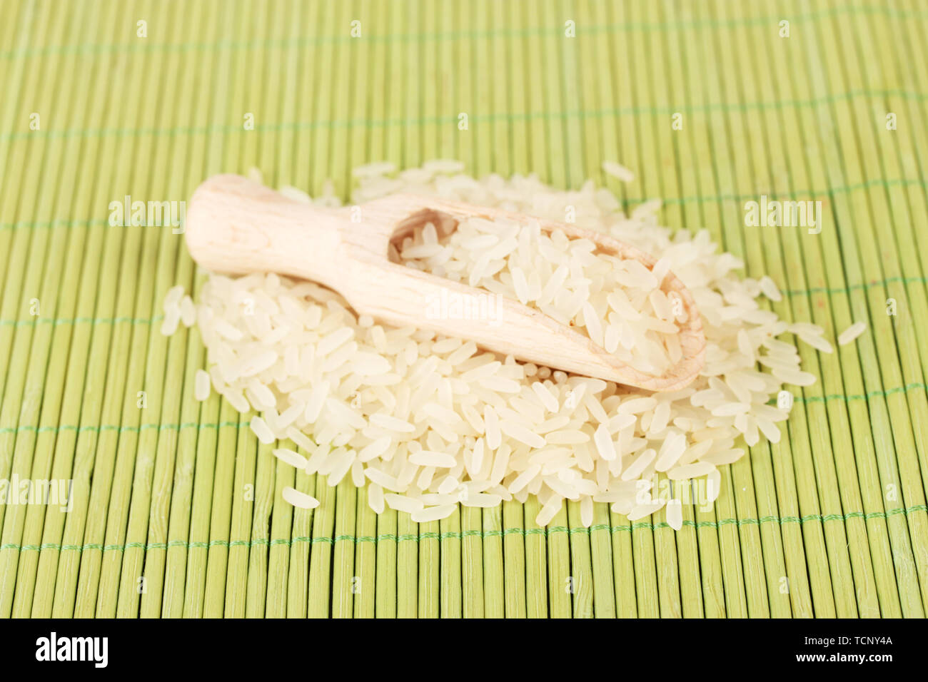 rice in wooden scoop on bamboo mat Stock Photo - Alamy