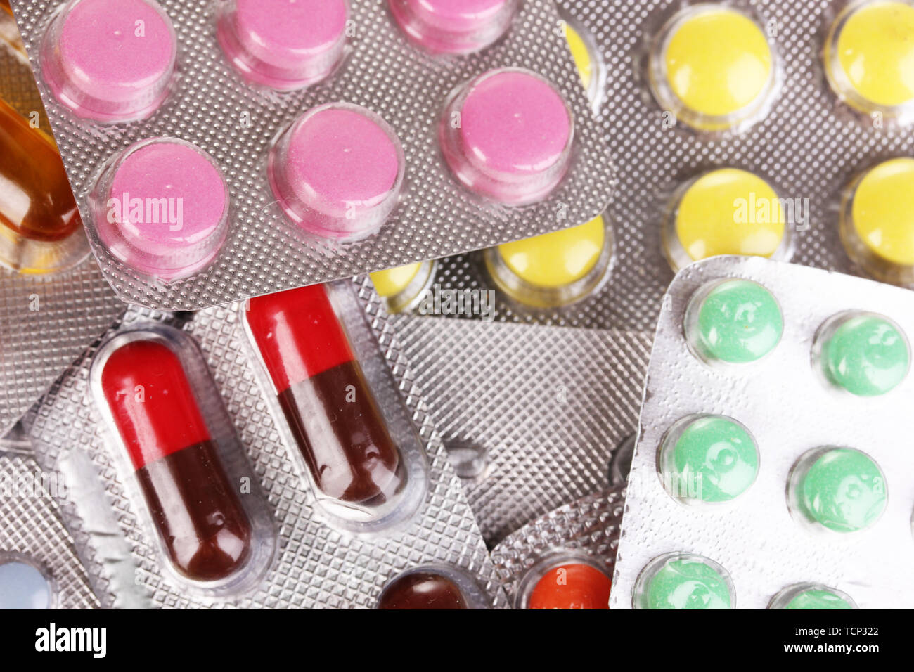 Capsules and pills packed in blisters close-up background Stock Photo ...