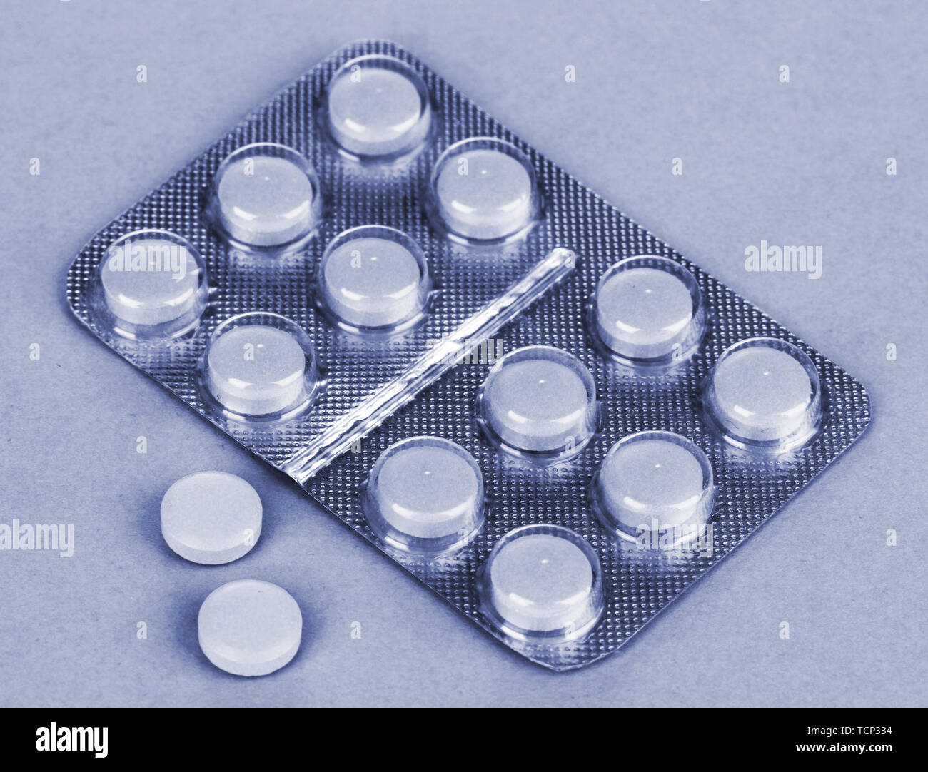 Tablets packed in blisters in grey light Stock Photo - Alamy