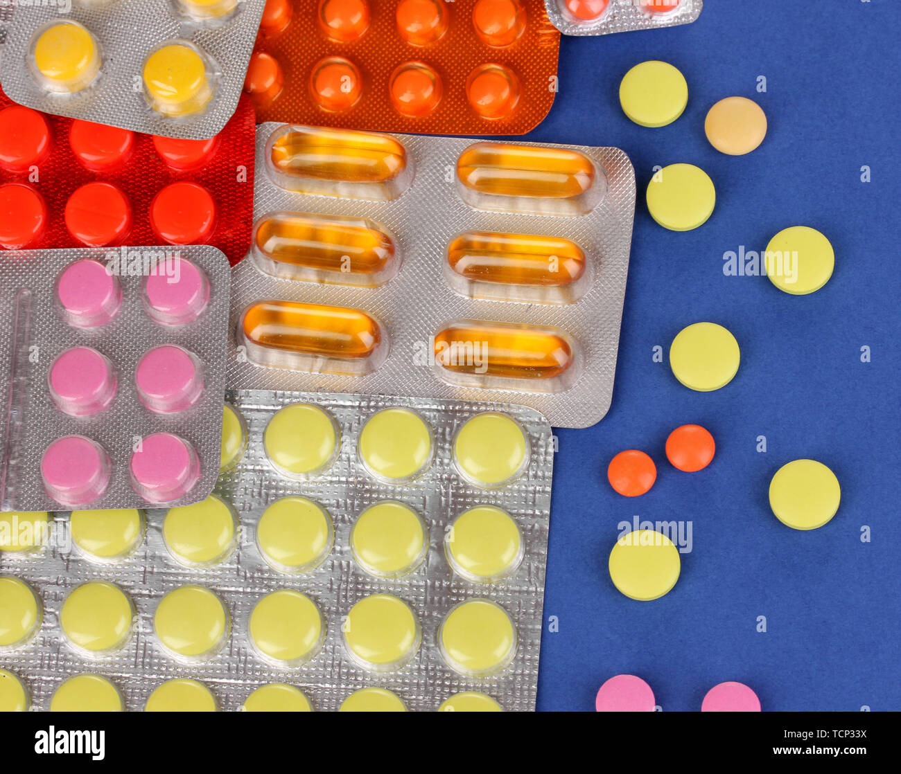 Capsules and pills packed in blisters on blue background Stock Photo ...