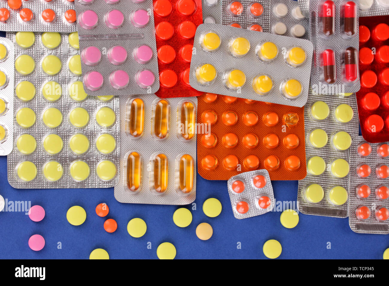 Capsules and pills packed in blisters on blue background Stock Photo ...