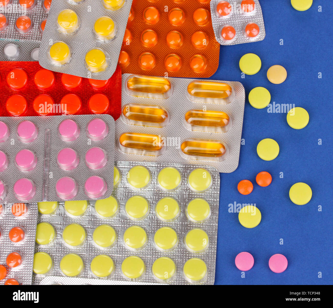 Capsules and pills packed in blisters on blue background Stock Photo ...