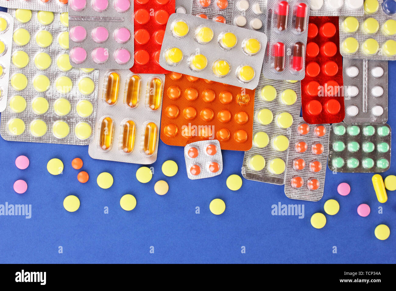 Capsules and pills packed in blisters on blue background Stock Photo ...