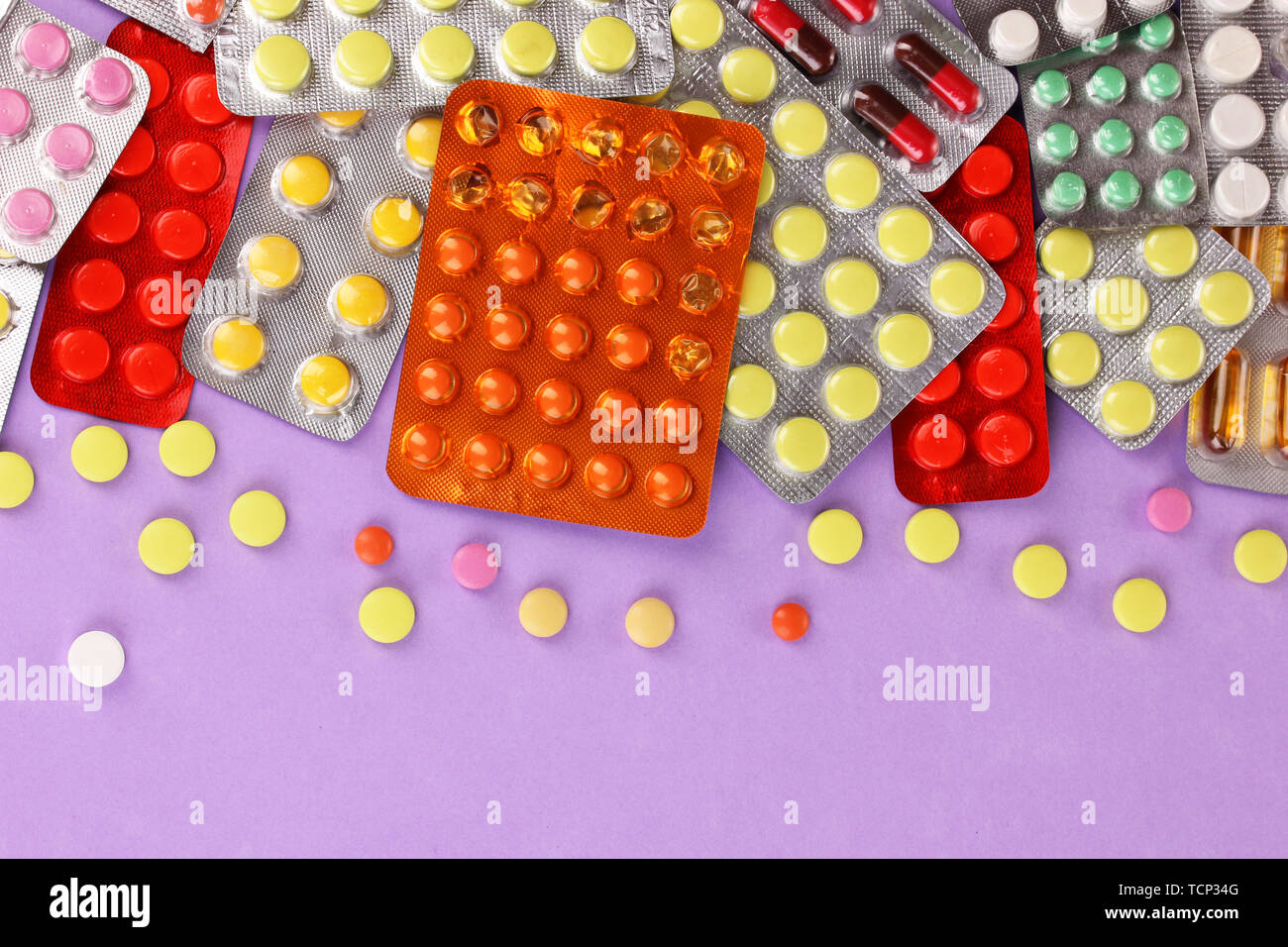 Capsules and pills packed in blisters on purple background Stock Photo ...