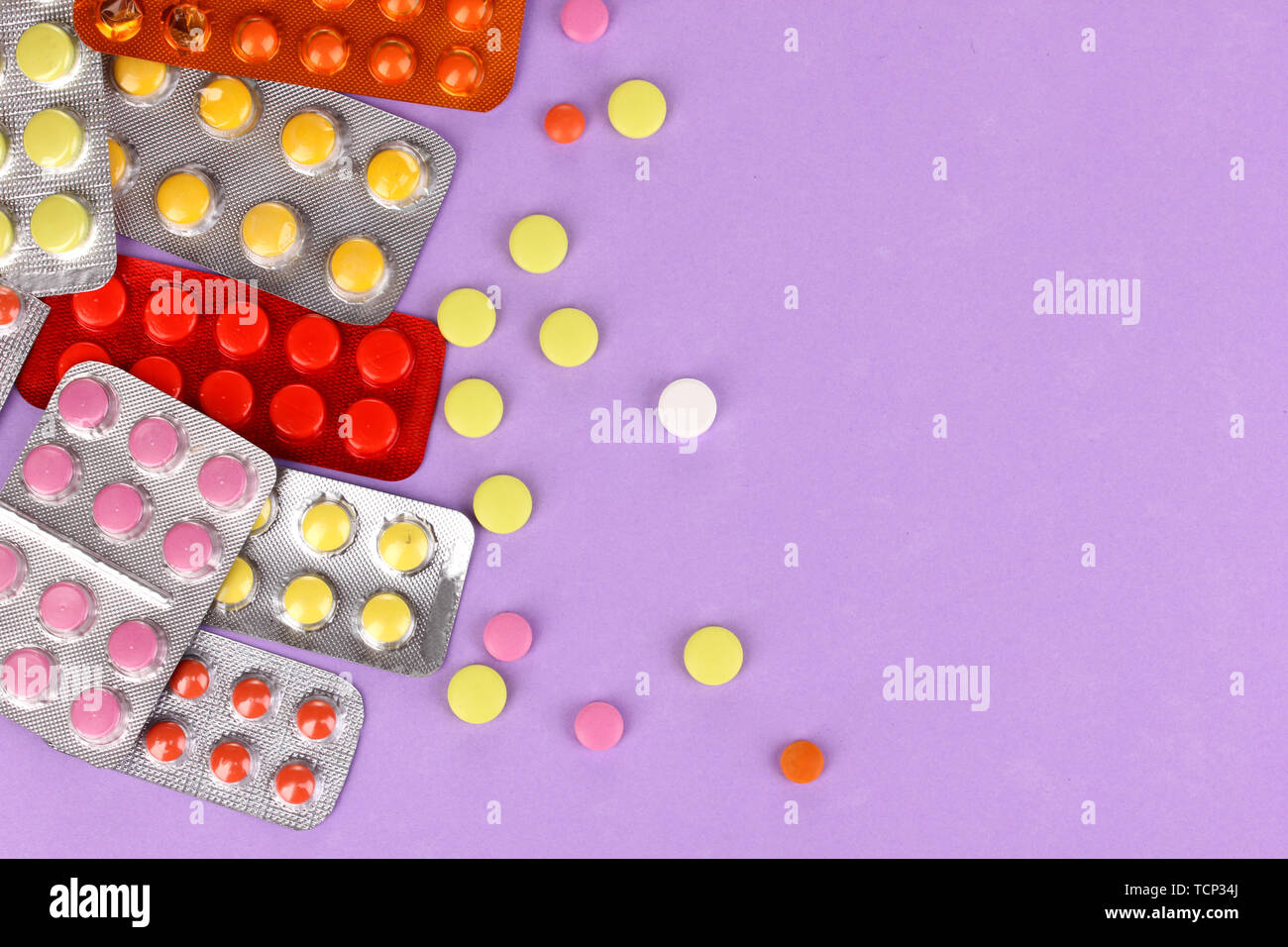 Capsules and pills packed in blisters on purple background Stock Photo ...