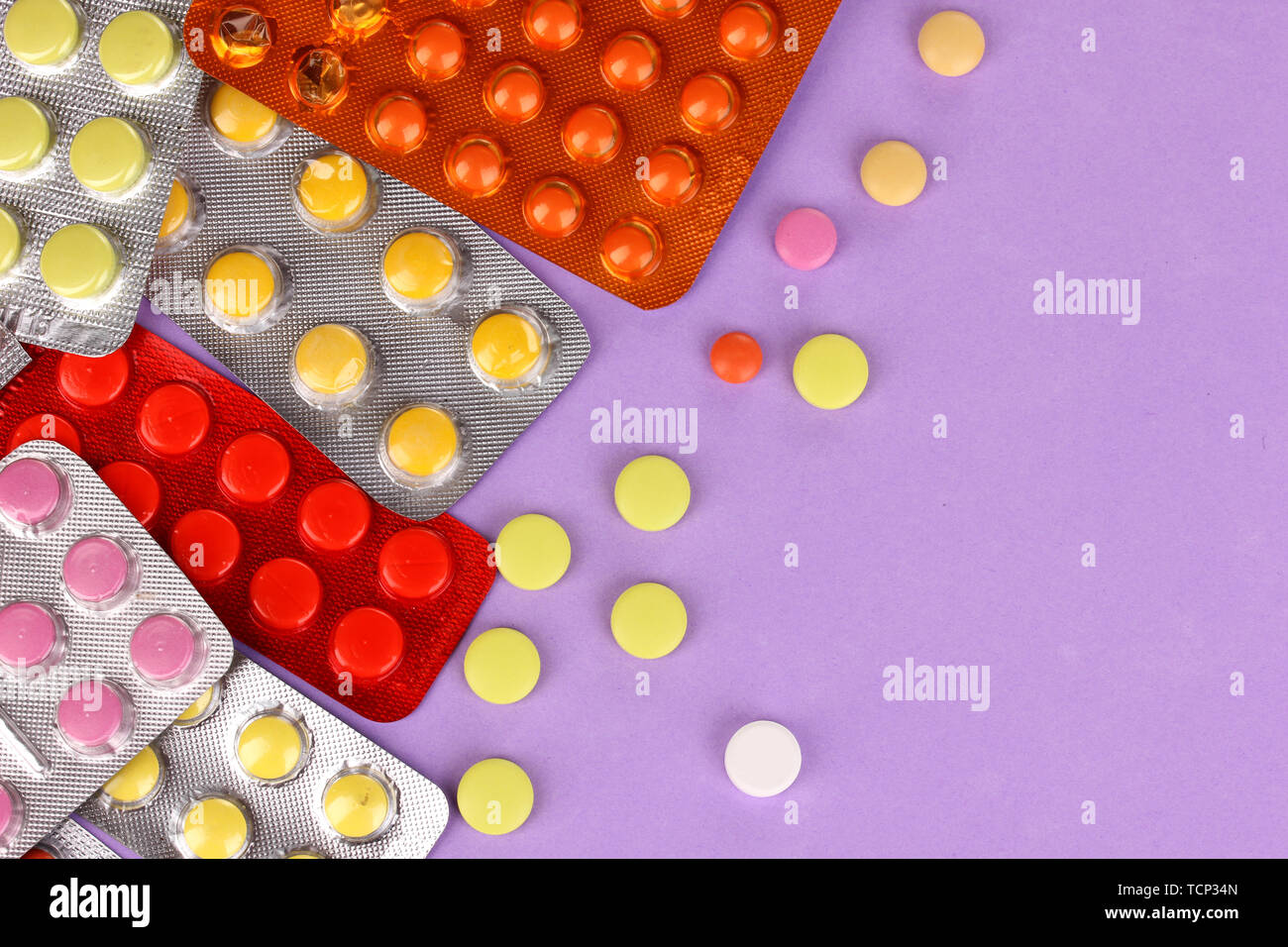 Capsules and pills packed in blisters on purple background Stock Photo ...