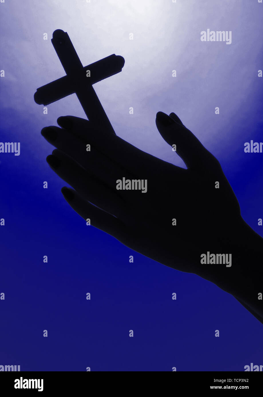 Female hands with crucifix, on bright blue background Stock Photo - Alamy