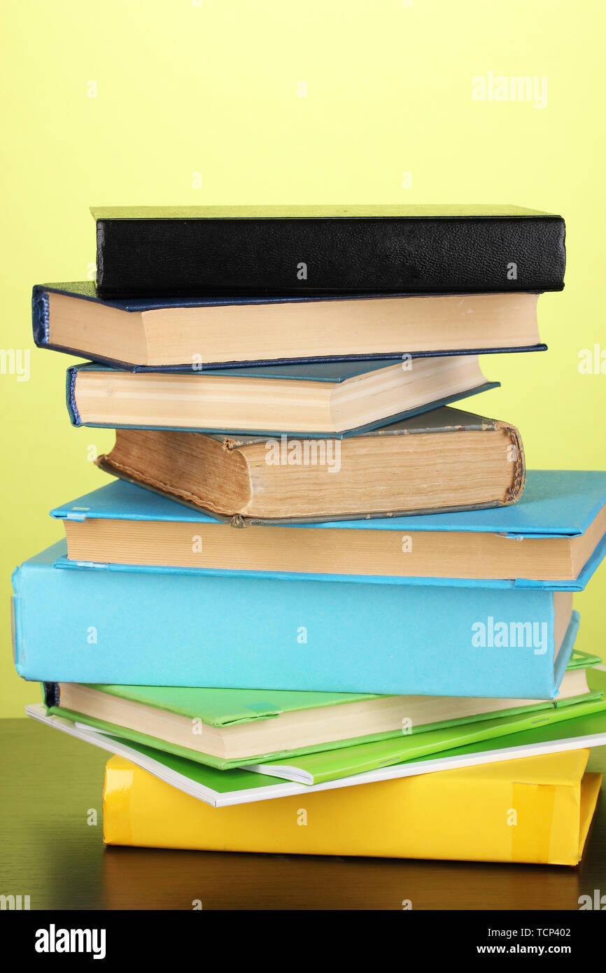 Stack of interesting books and magazines on wooden table on green ...