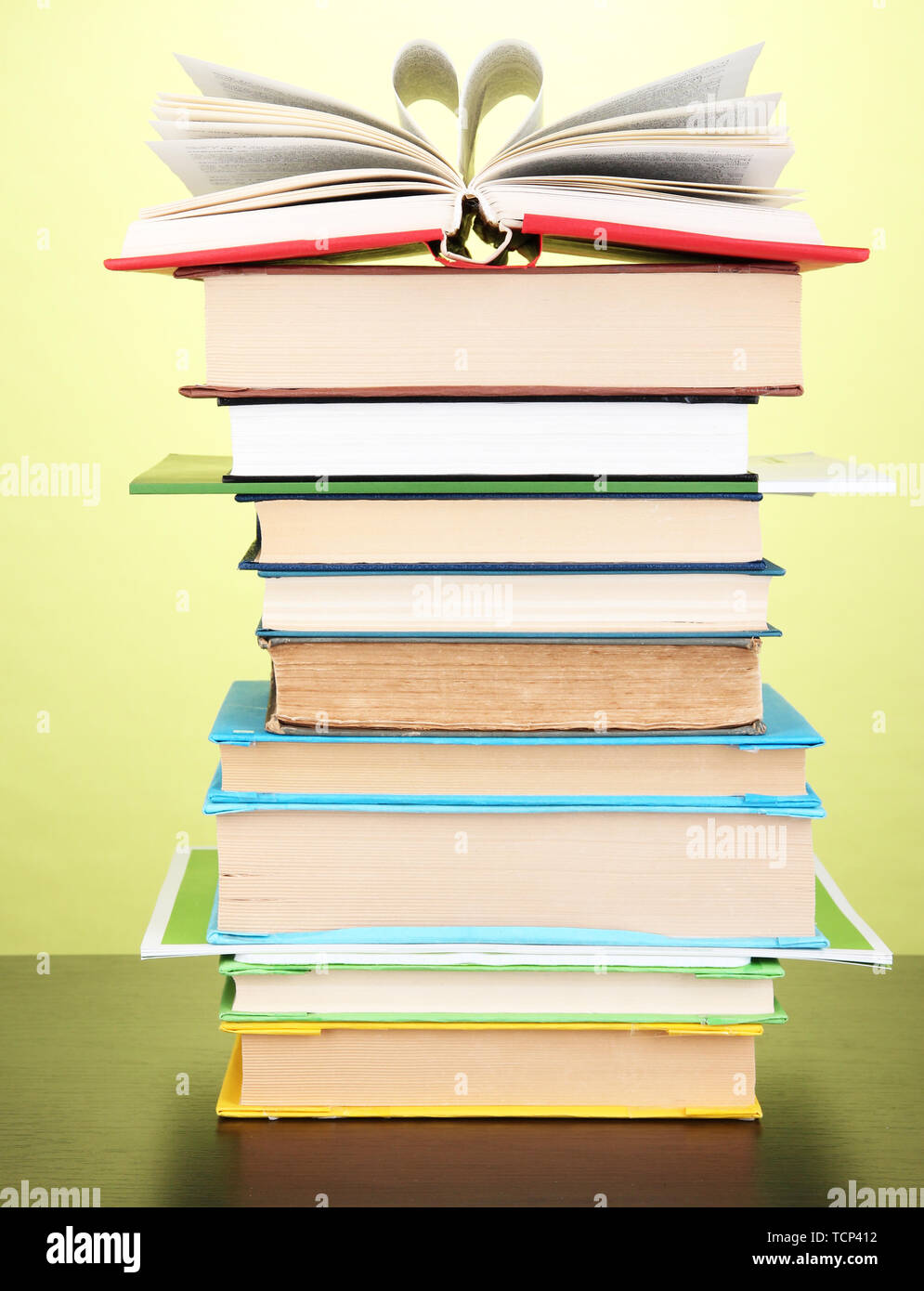 Stack of interesting books and magazines on wooden table on green ...