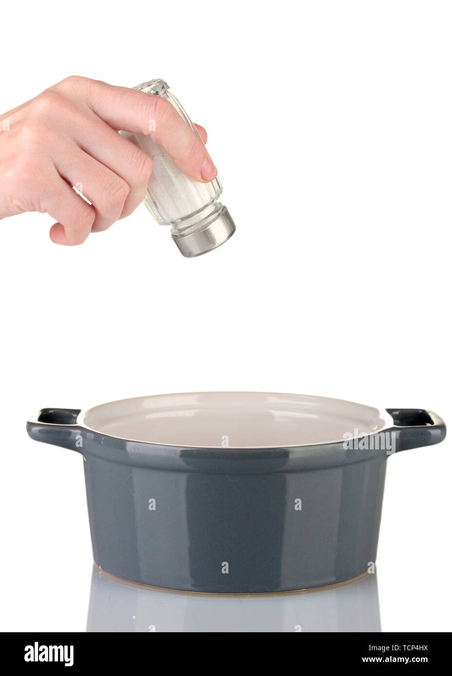 Hand adding salt using salt shaker isolated on white Stock Photo - Alamy