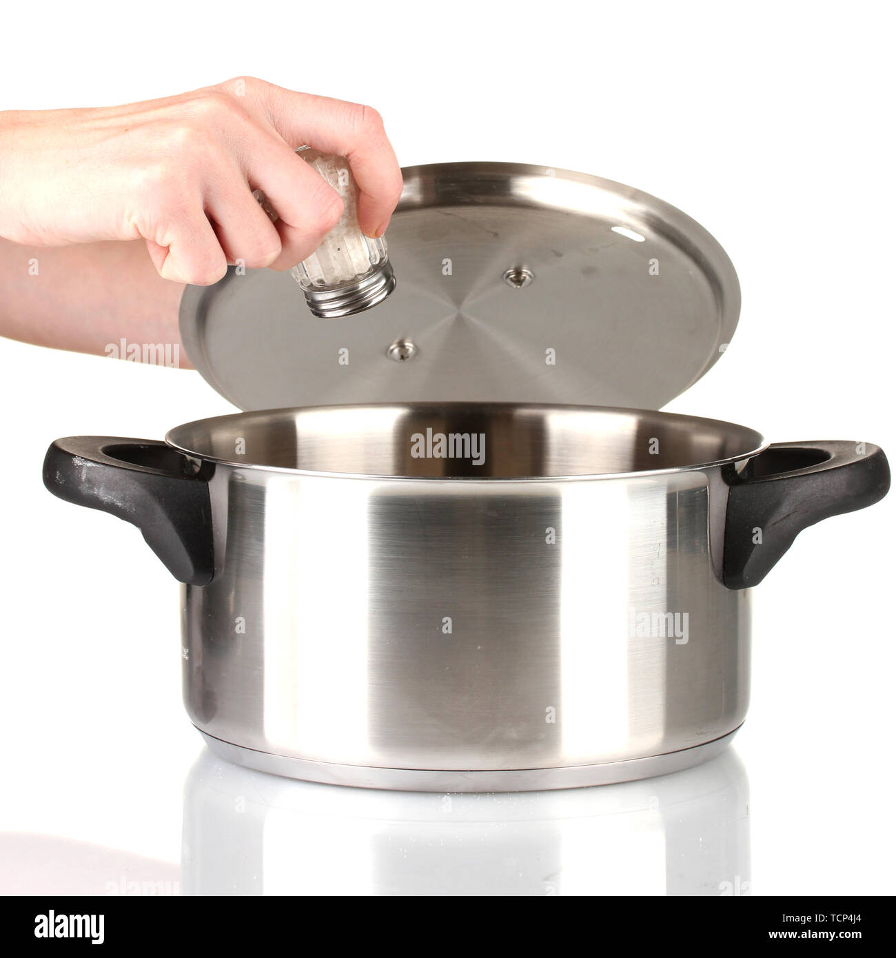 Hand adding salt using salt shaker isolated on white Stock Photo - Alamy
