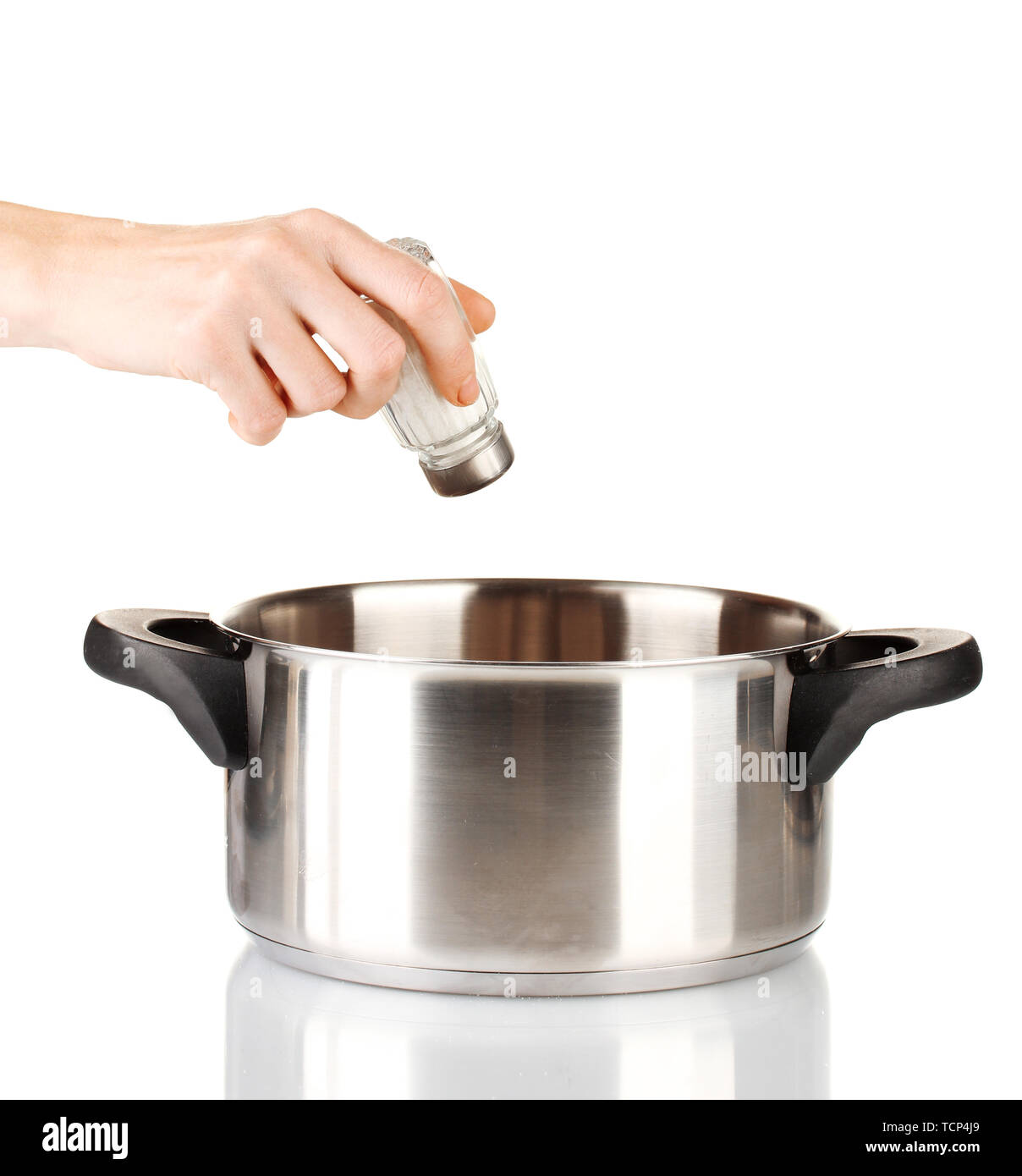Hand adding salt using salt shaker isolated on white Stock Photo - Alamy