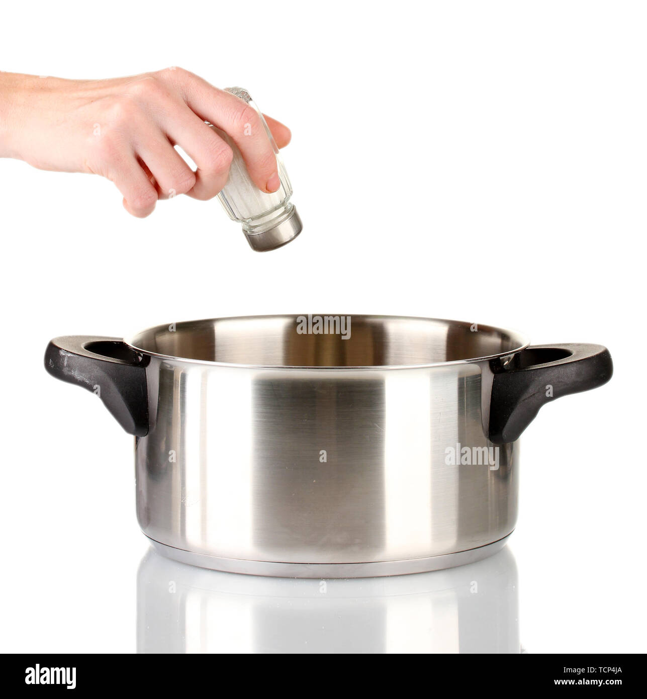 Hand adding salt using salt shaker isolated on white Stock Photo - Alamy