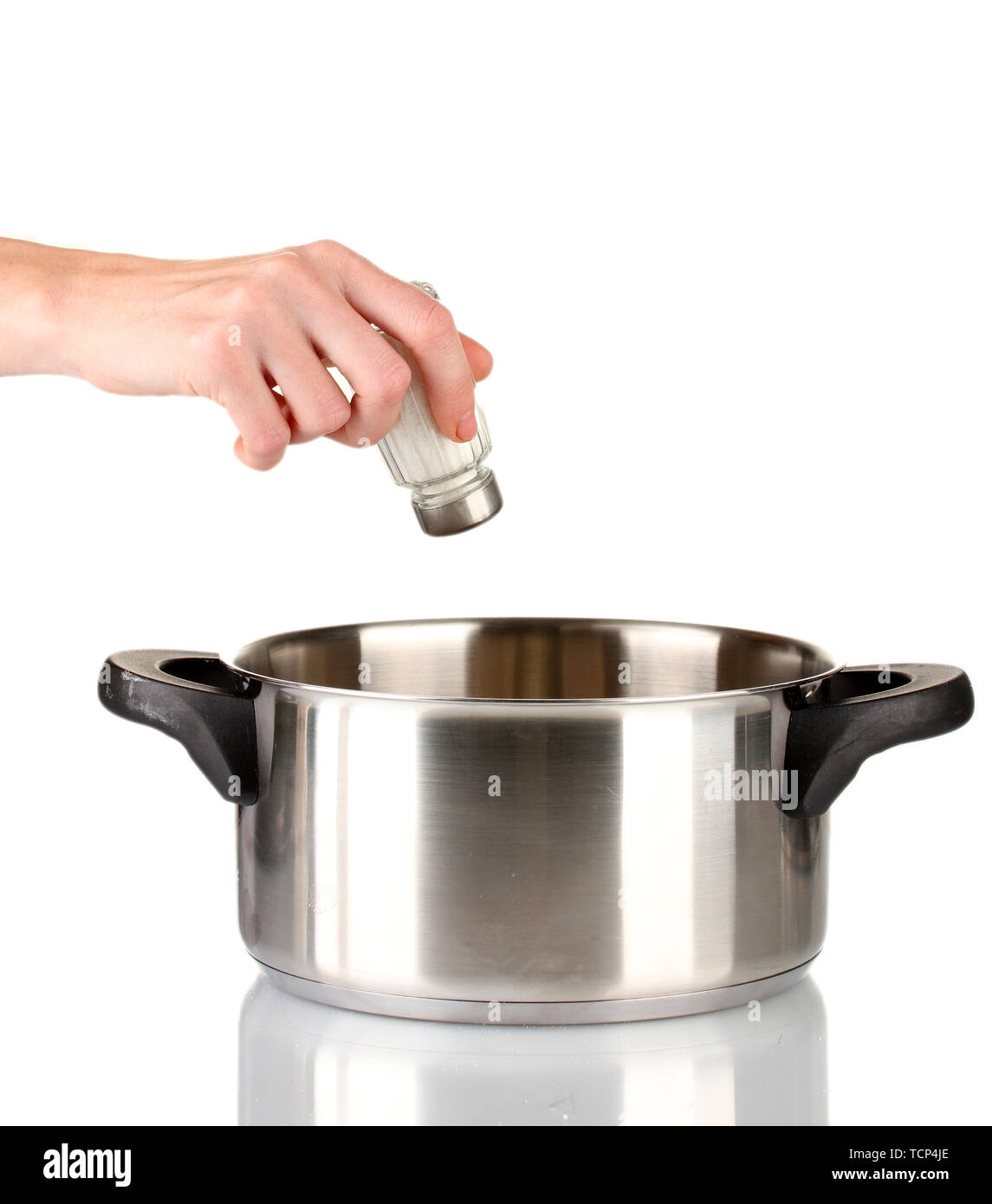 Hand adding salt using salt shaker isolated on white Stock Photo - Alamy
