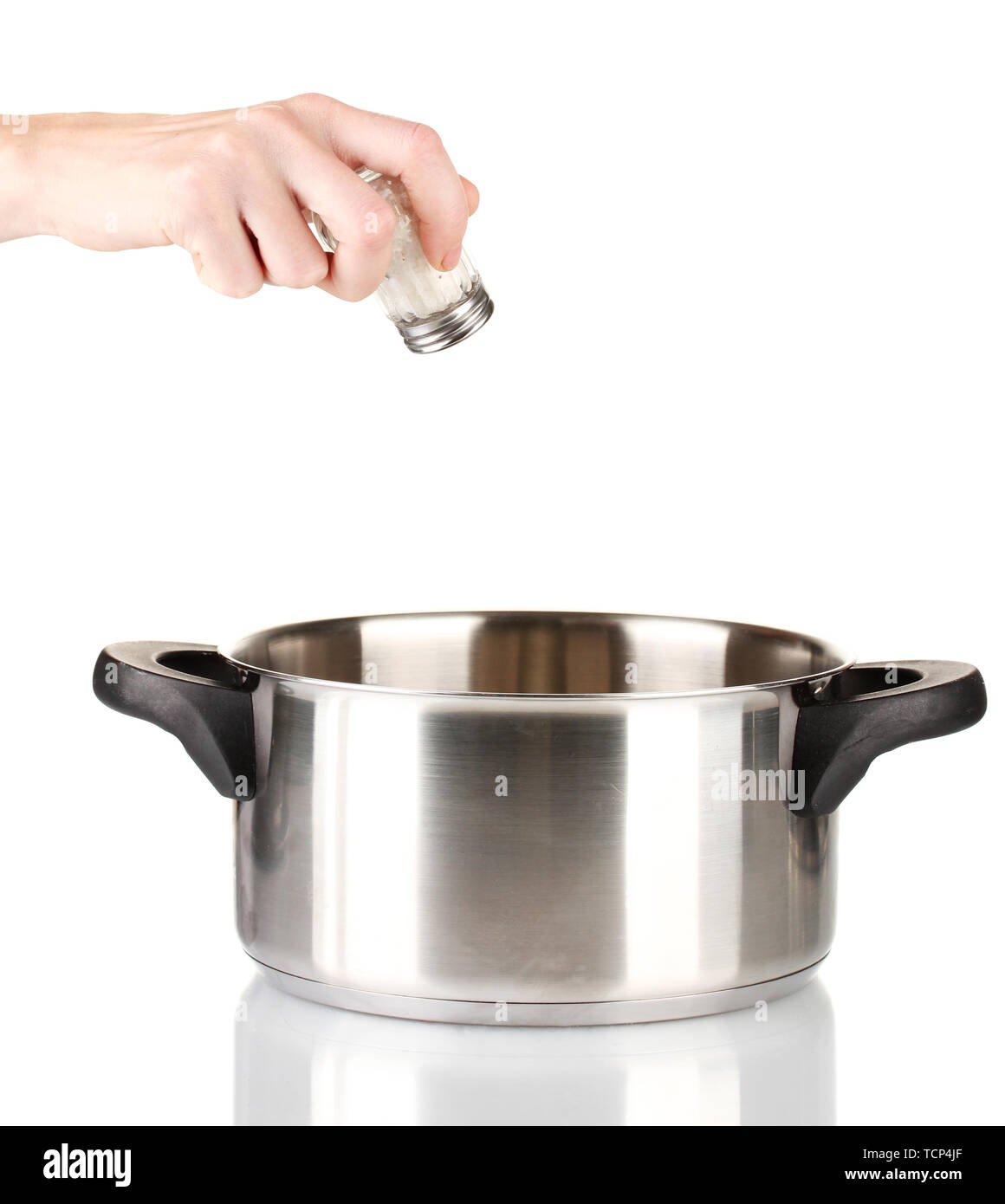 Hand adding salt using salt shaker isolated on white Stock Photo - Alamy