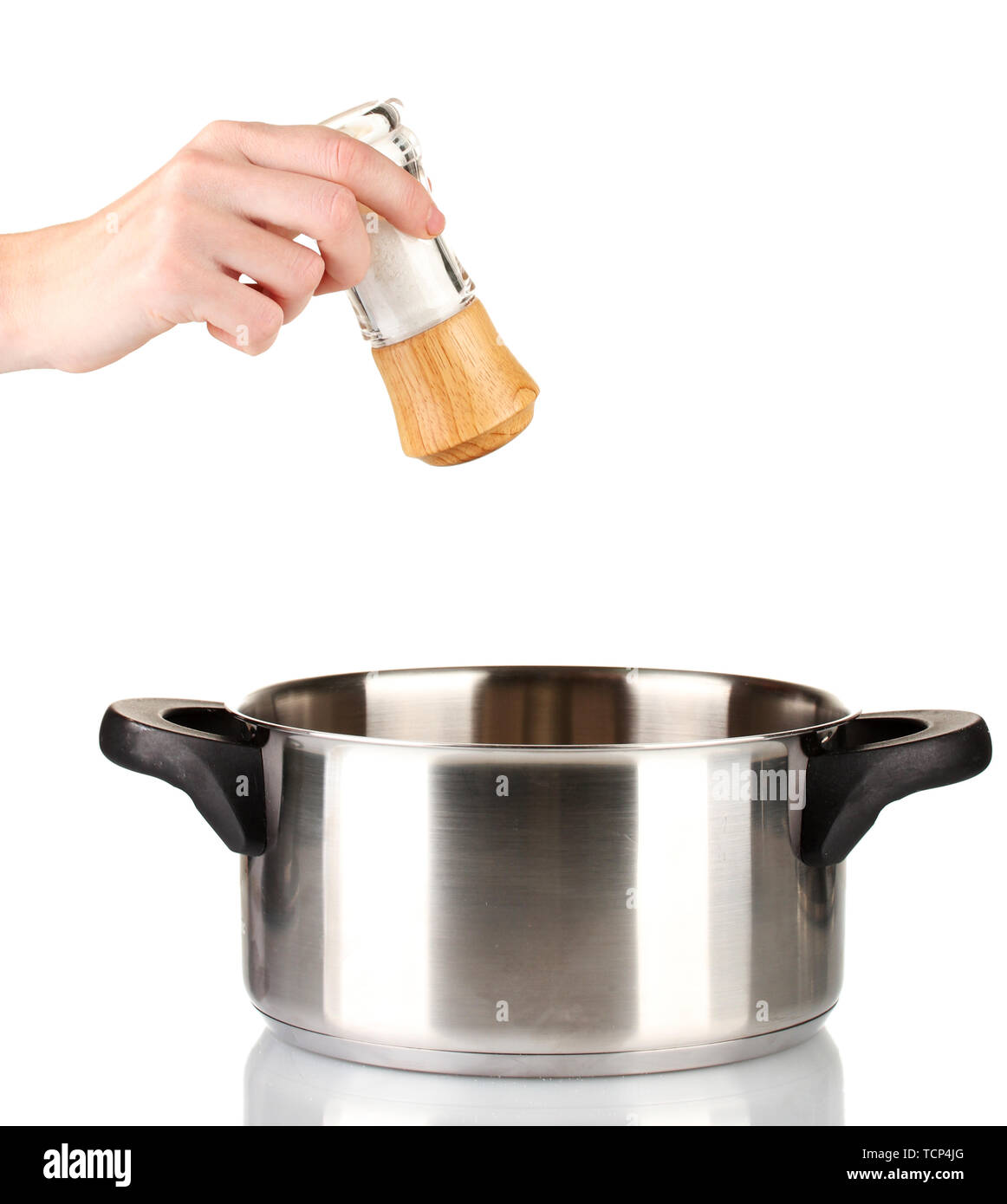 Hand adding salt using salt shaker isolated on white Stock Photo - Alamy