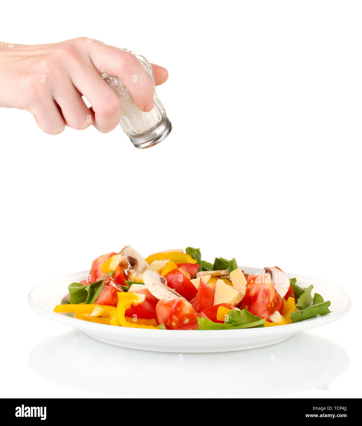 Hand adding salt using salt shaker isolated on white Stock Photo - Alamy