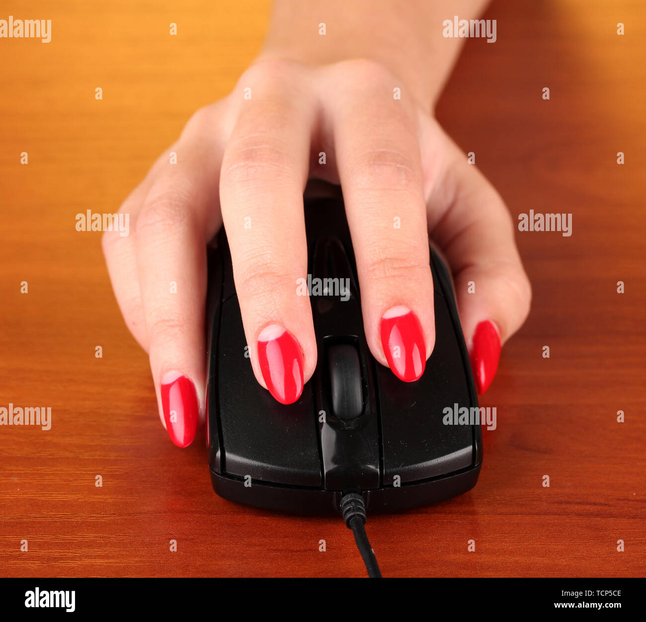 Closeup of female fingers and nails on computer mouse on wooden ...