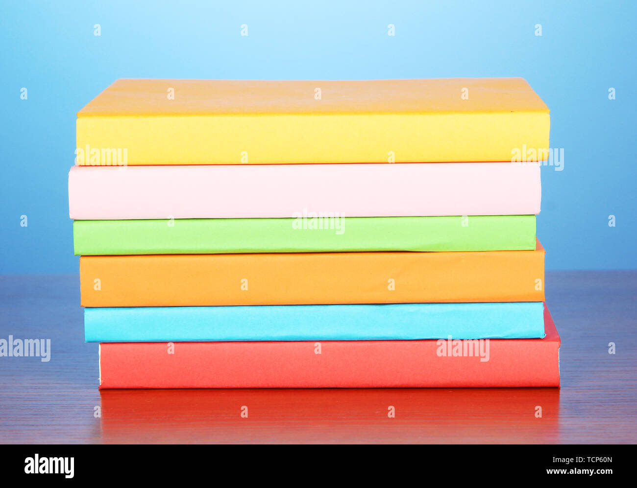 Stack of multicolor books on blue background Stock Photo - Alamy