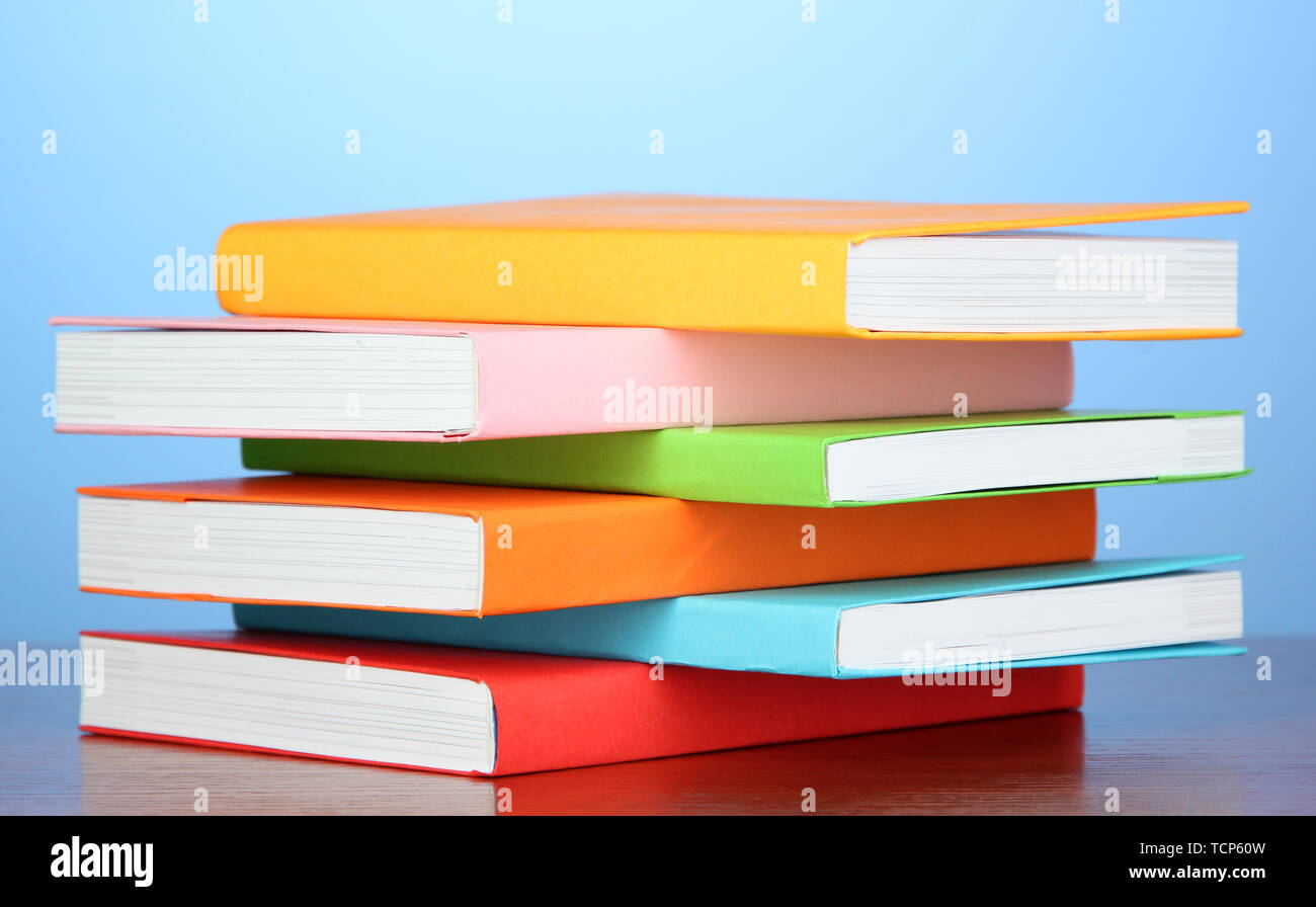Stack of multicolor books on blue background Stock Photo - Alamy