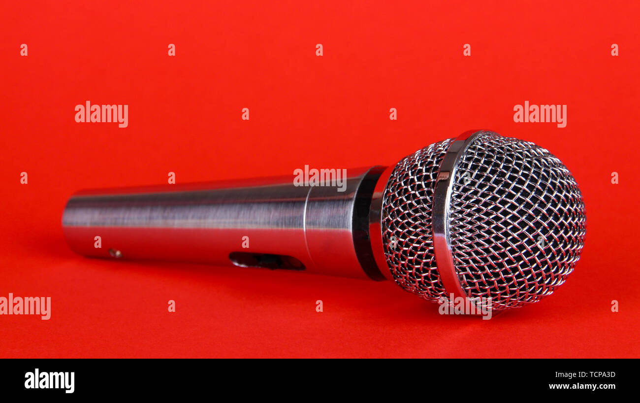 Silver microphone on red background Stock Photo - Alamy