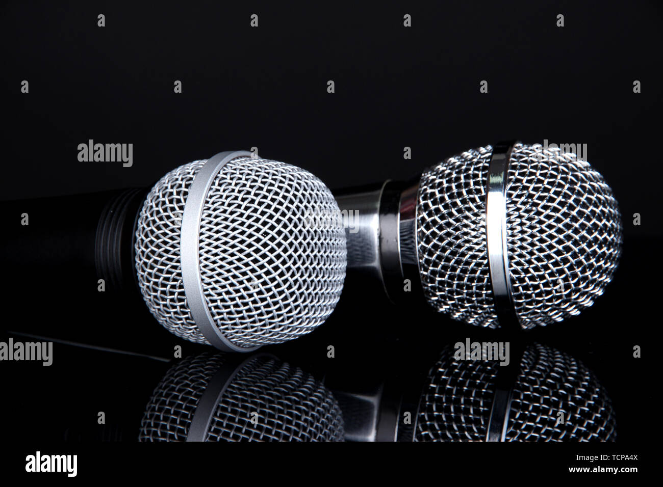Silver and black microphones isolated on black Stock Photo - Alamy