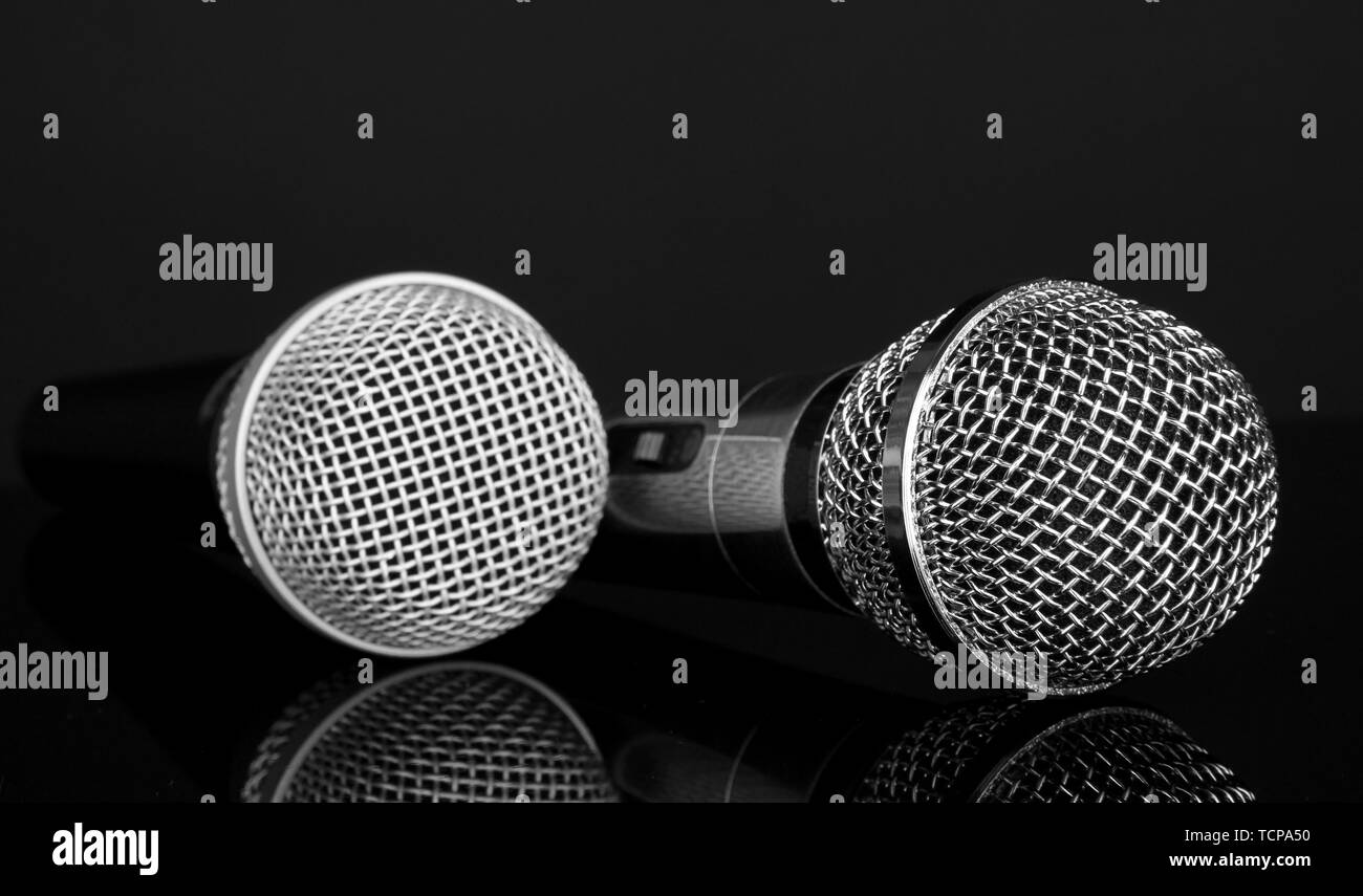 Silver and black microphones isolated on black Stock Photo - Alamy