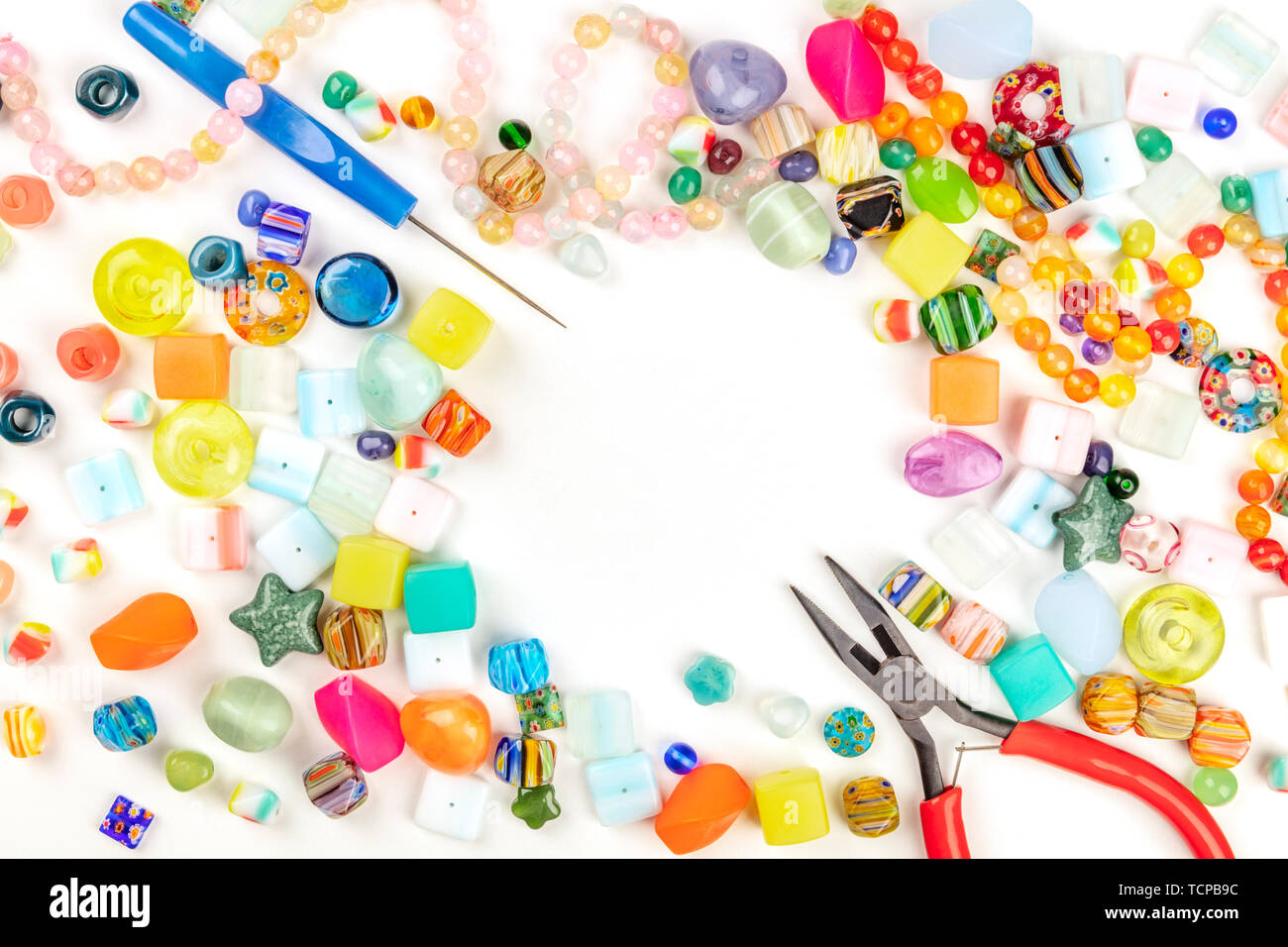 Many different beads with tools for making jewellery, shot from the top ...
