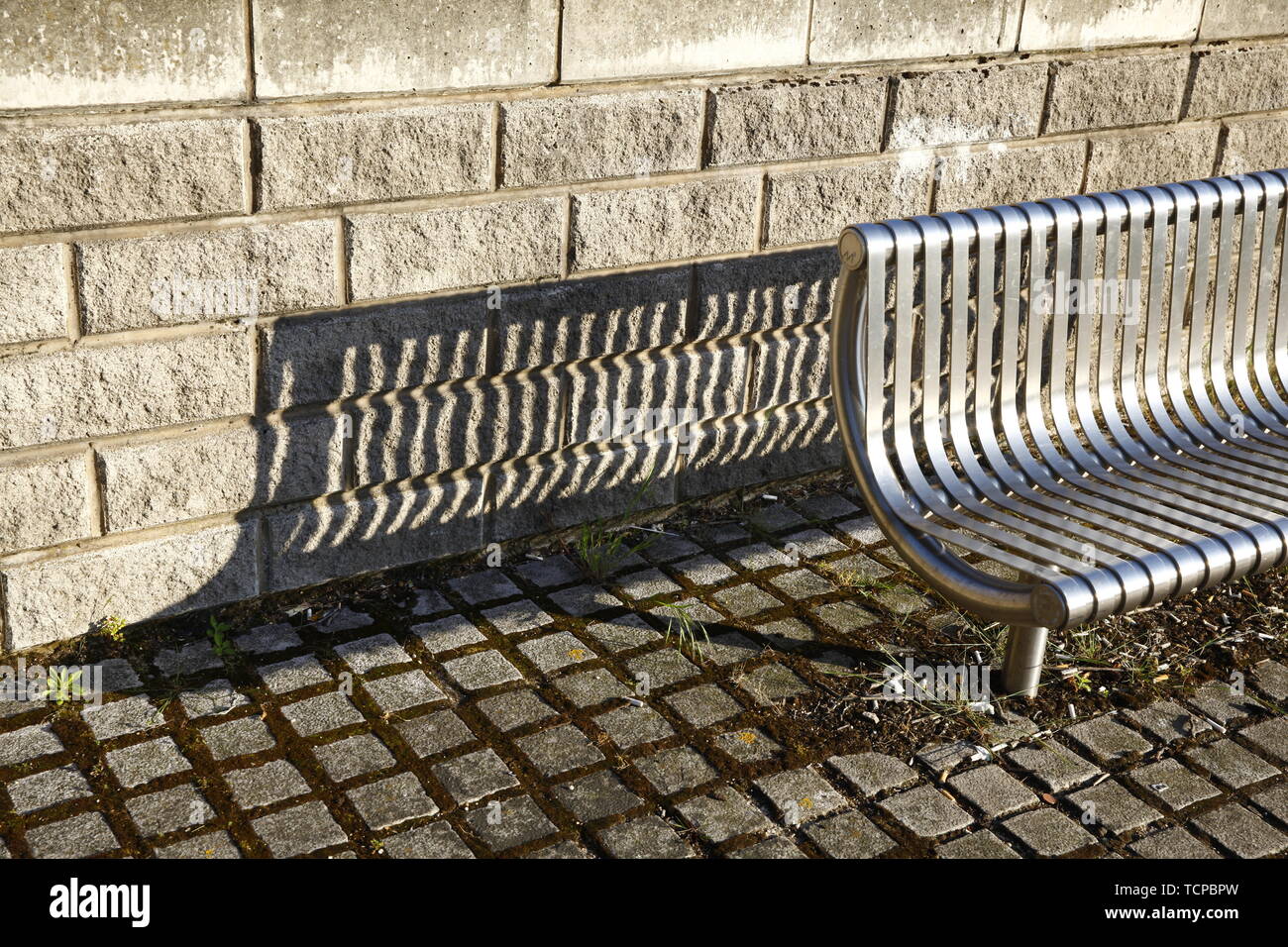 Steel bench with long shadow, in low evening light Stock Photo - Alamy
