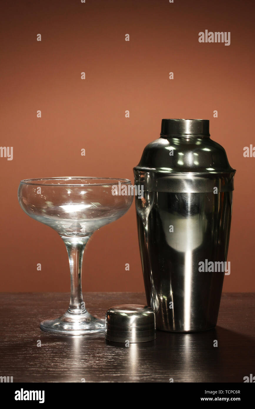 Cocktail shaker and cocktail glass on color background Stock Photo - Alamy