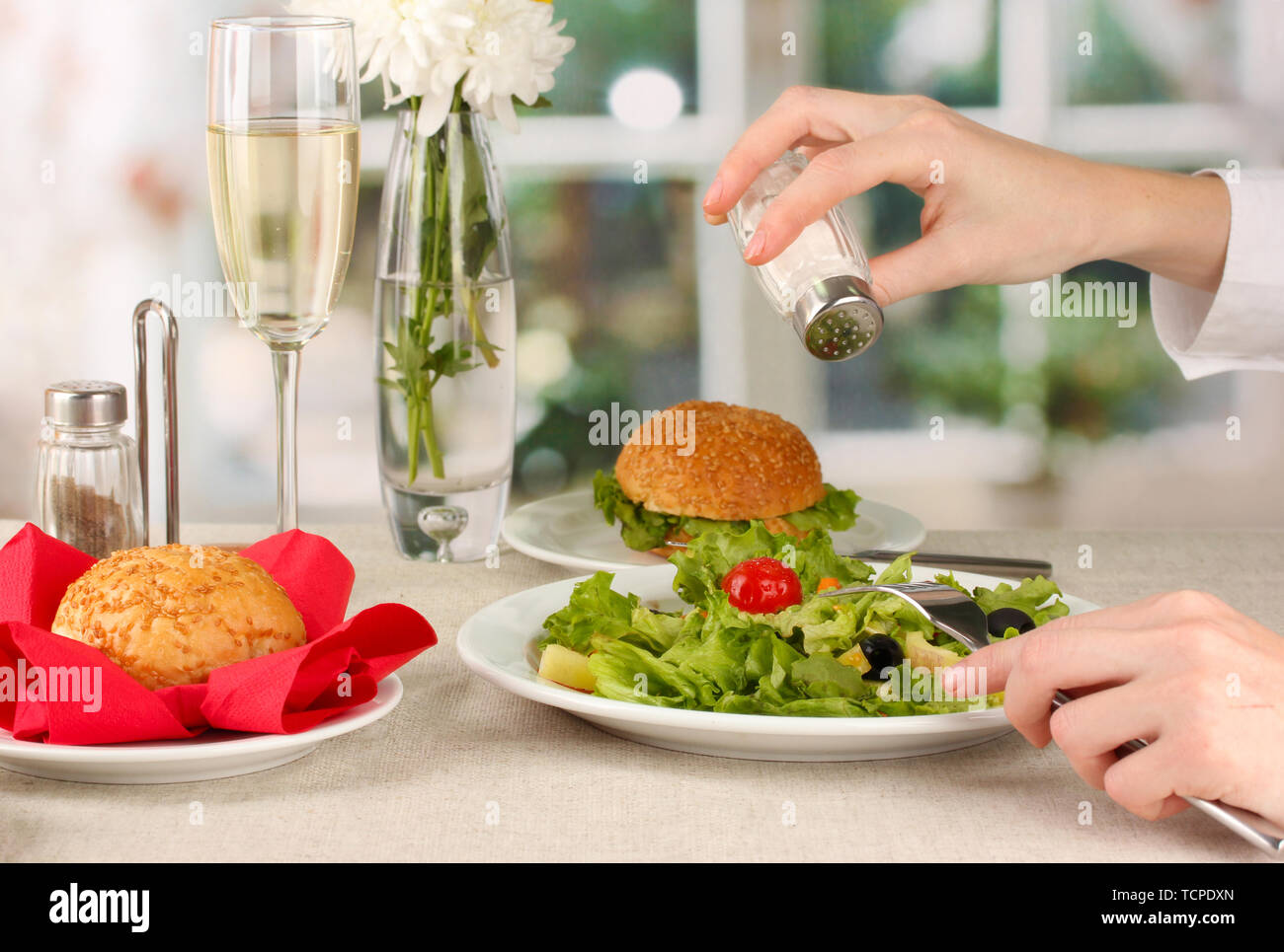 Female hand with dinner on bright background Stock Photo - Alamy