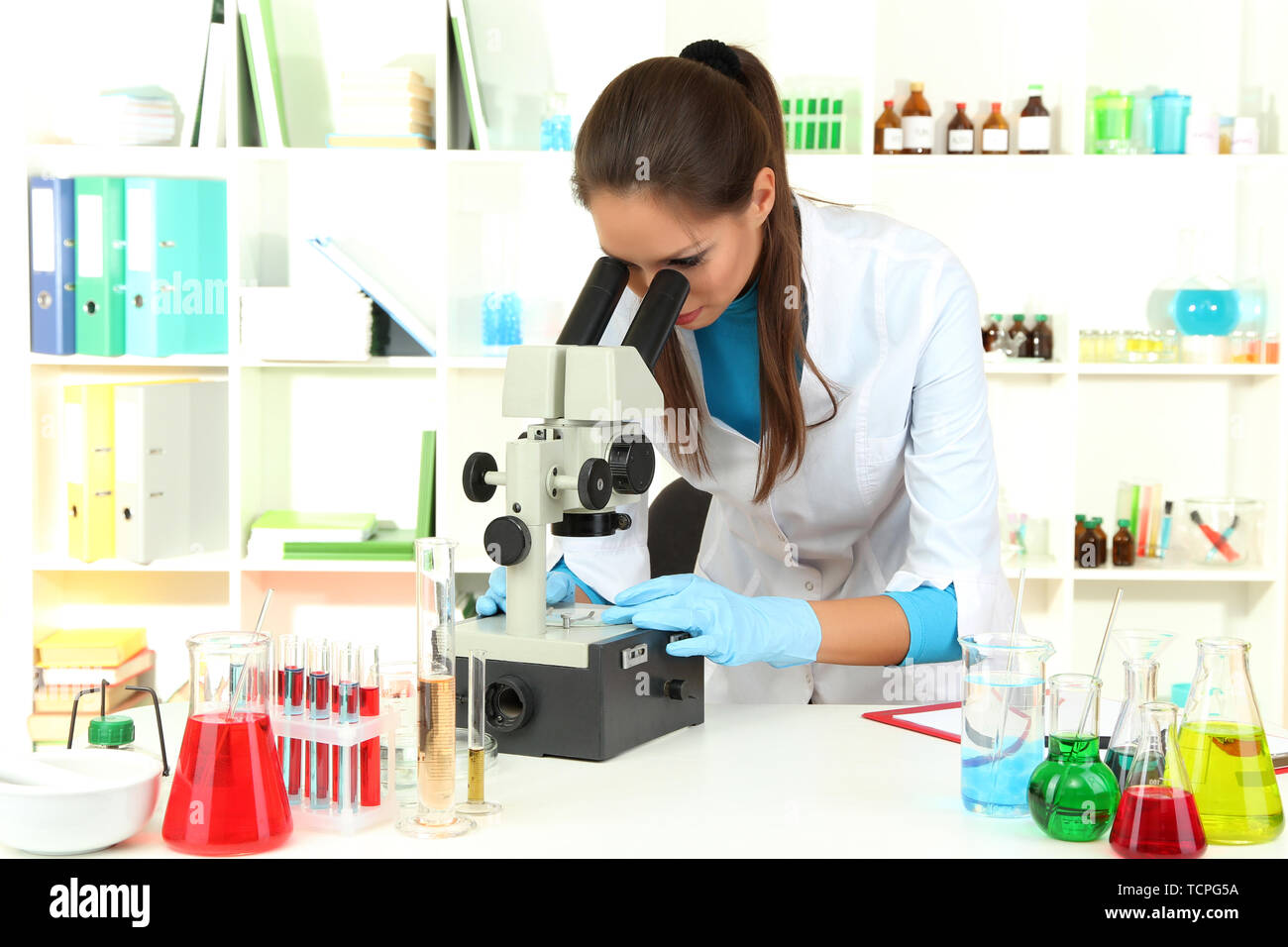 Young scientist looking into microscope in laboratory Stock Photo - Alamy
