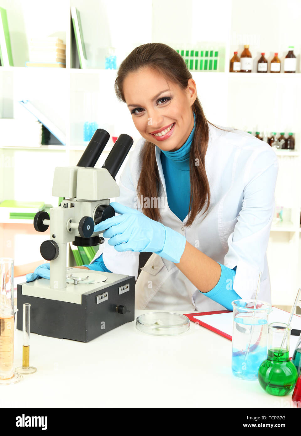 Young scientist looking into microscope in laboratory Stock Photo - Alamy