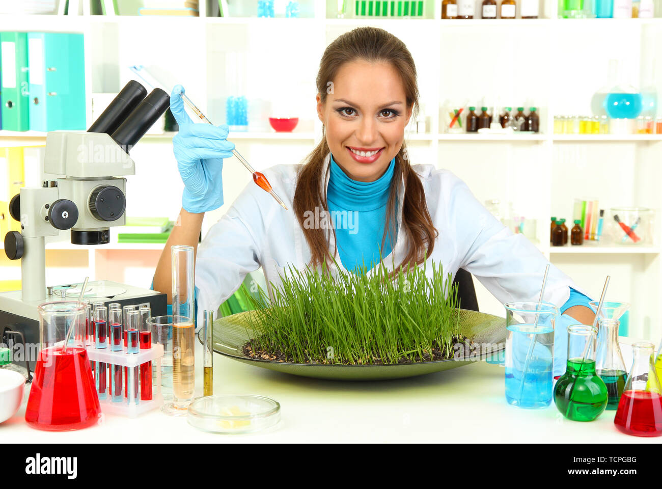 Young female scientist is conducting experiments with plants in ...