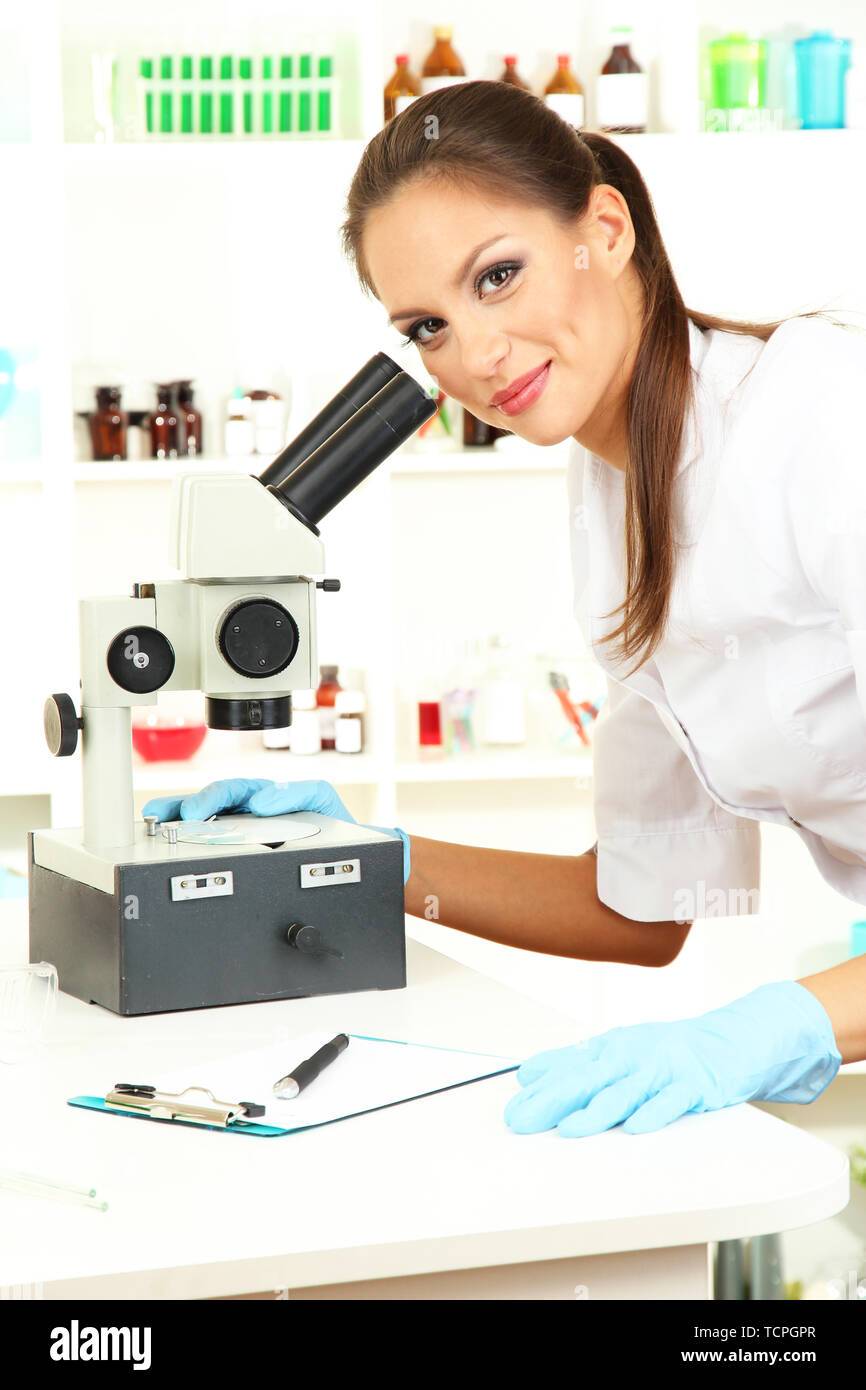 Young scientist looking into microscope in laboratory Stock Photo - Alamy