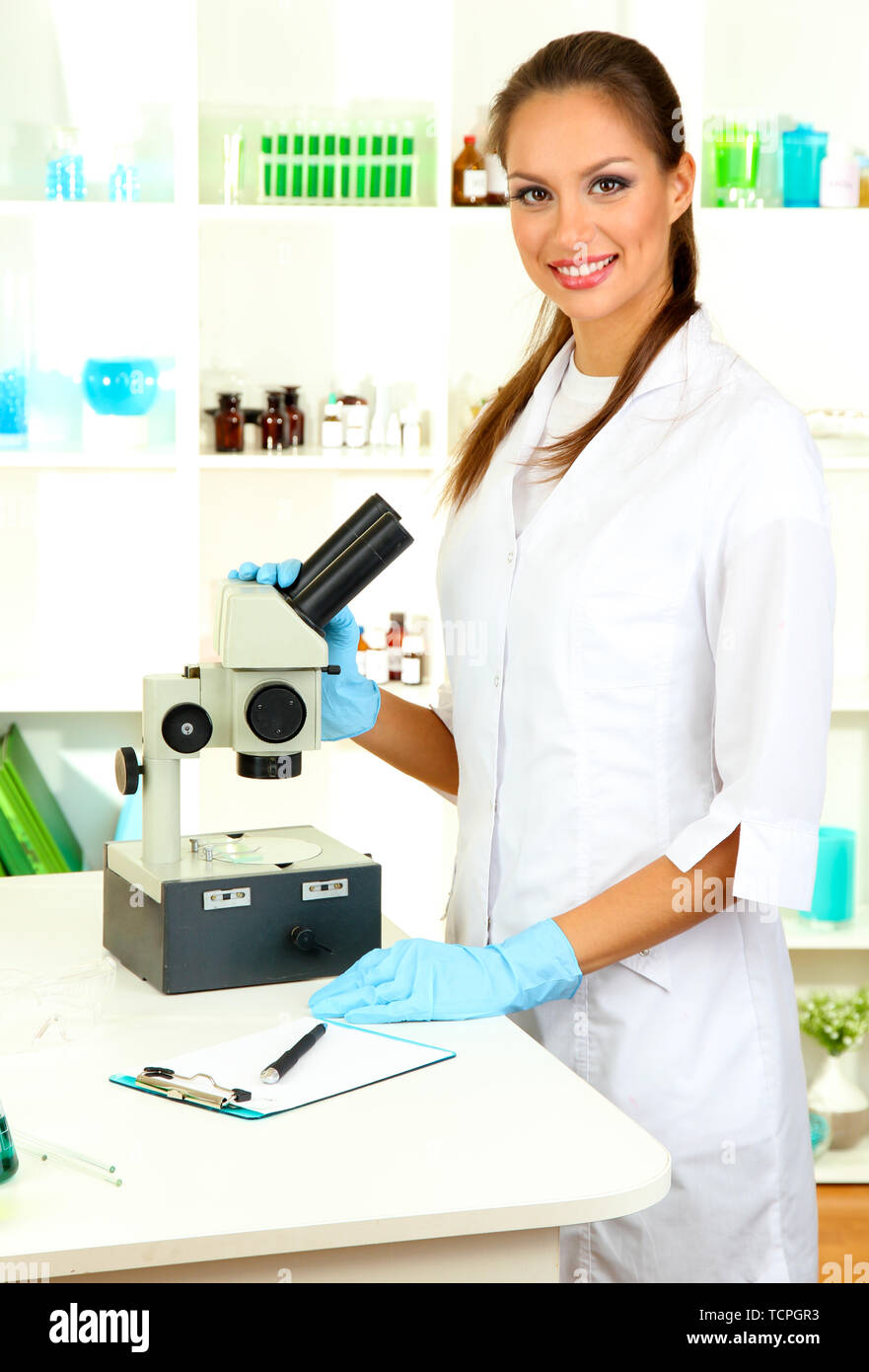 Young scientist looking into microscope in laboratory Stock Photo - Alamy