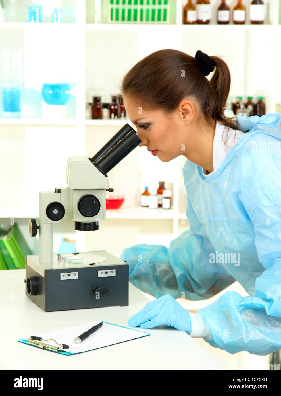 Young scientist looking into microscope in laboratory Stock Photo - Alamy