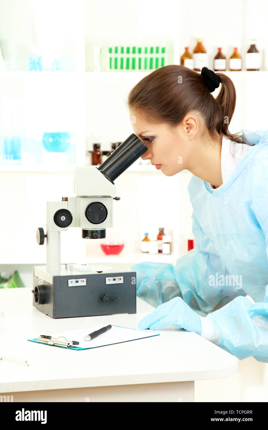 Young scientist looking into microscope in laboratory Stock Photo - Alamy