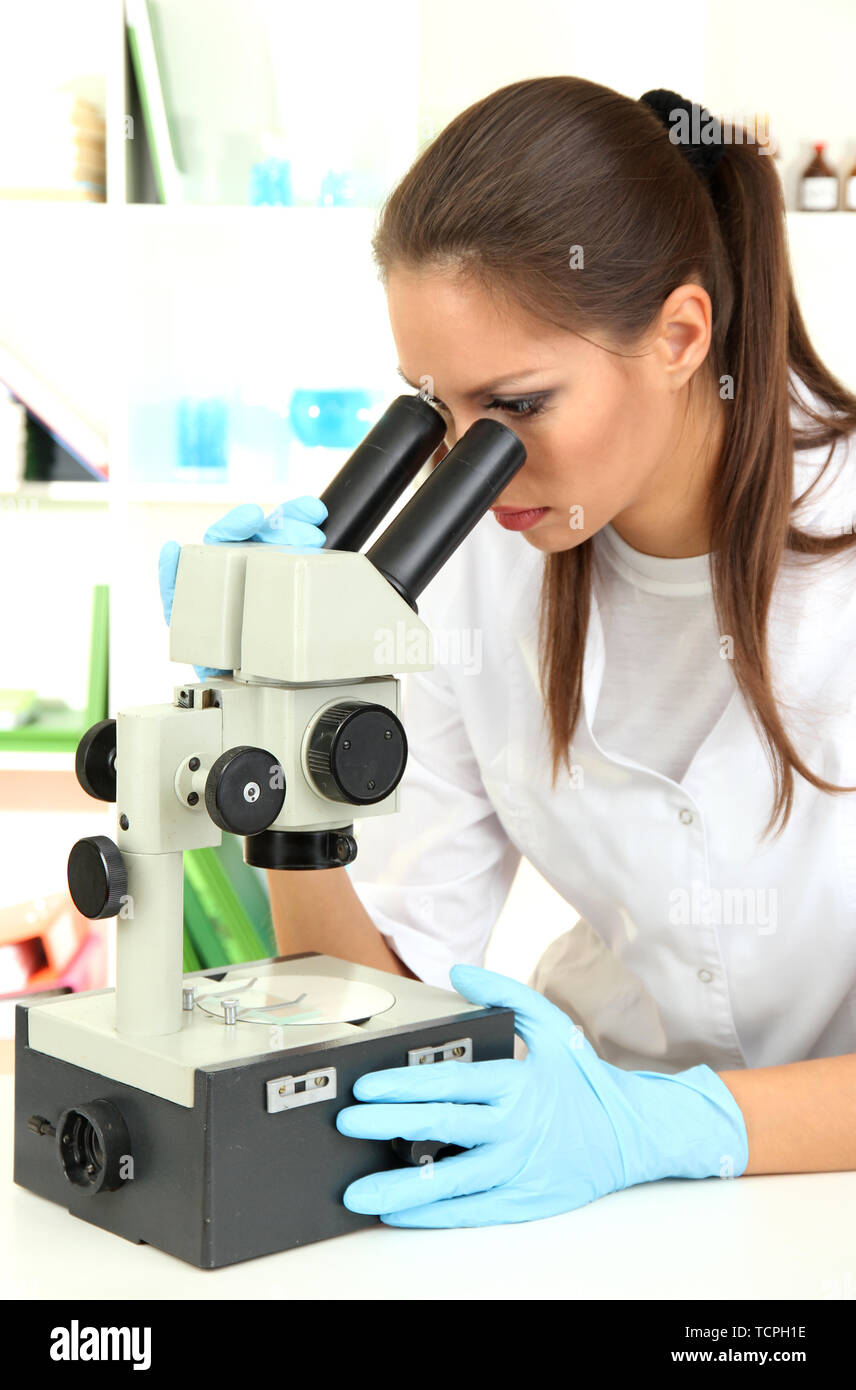 Young scientist looking into microscope in laboratory Stock Photo - Alamy