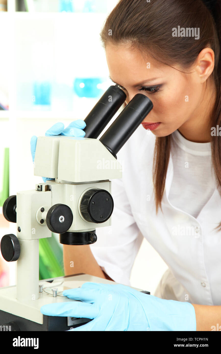 Young scientist looking into microscope in laboratory Stock Photo - Alamy