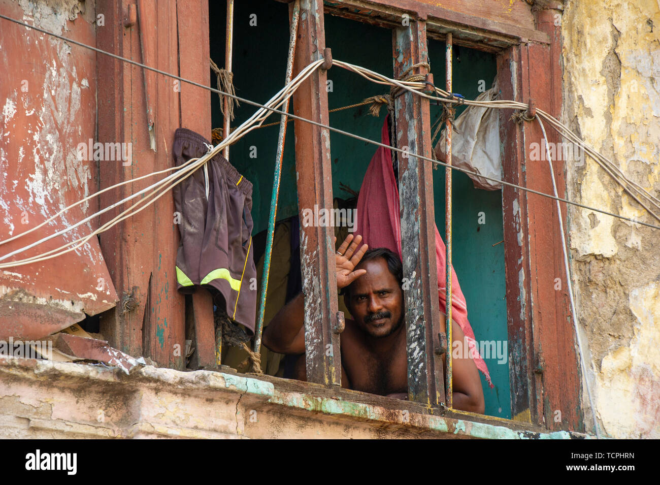 Poverty in Chennai, India, where a man waves from his bedroom window ...