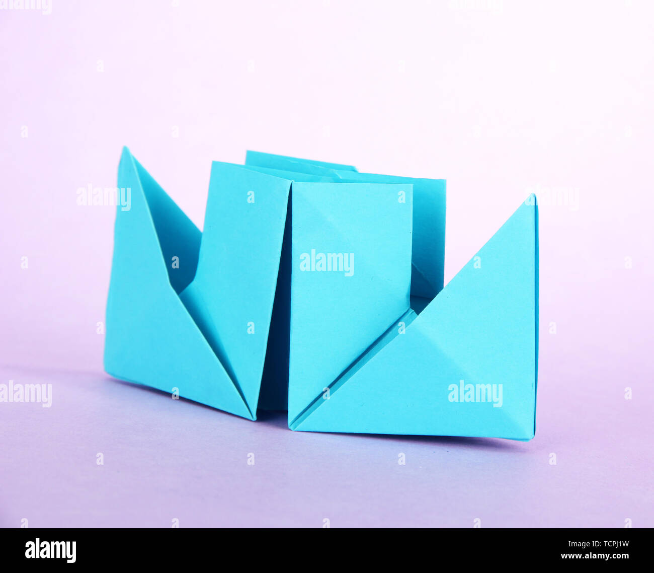 Origami paper steamer on purple background Stock Photo - Alamy