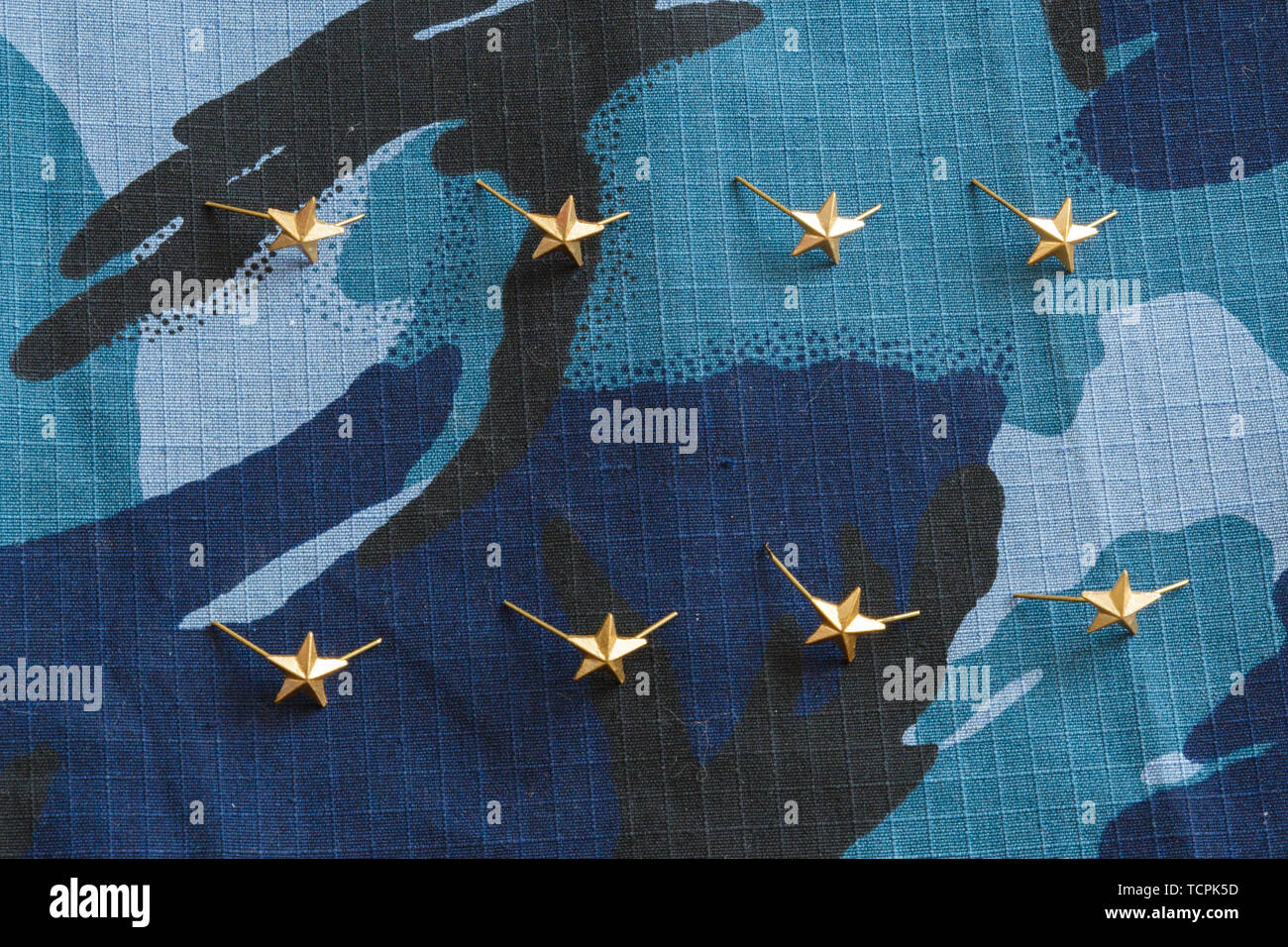 Gold stars for shoulder straps on blue camouflage fabric. Military ...