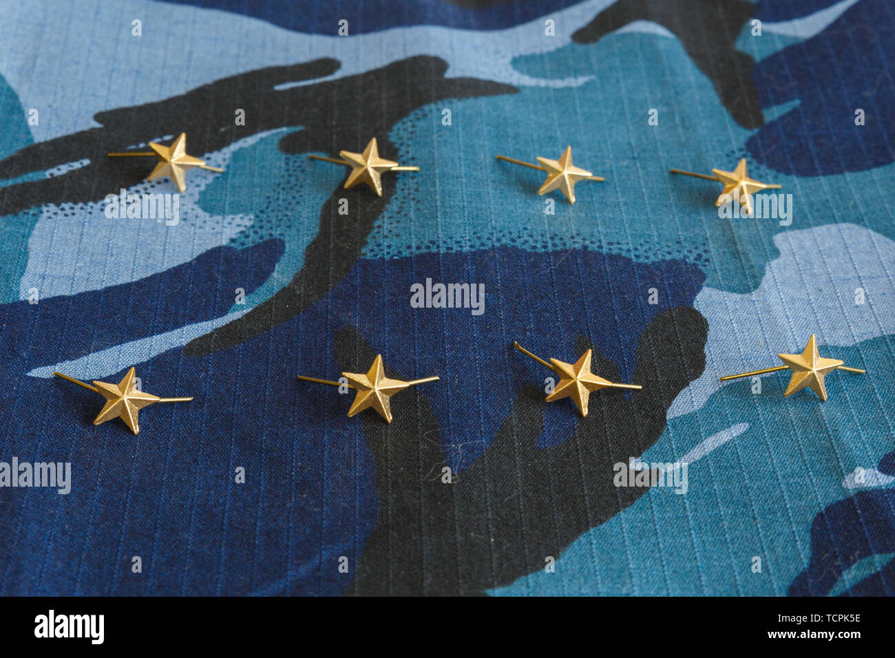 Gold stars for shoulder straps on blue camouflage fabric. Military ...