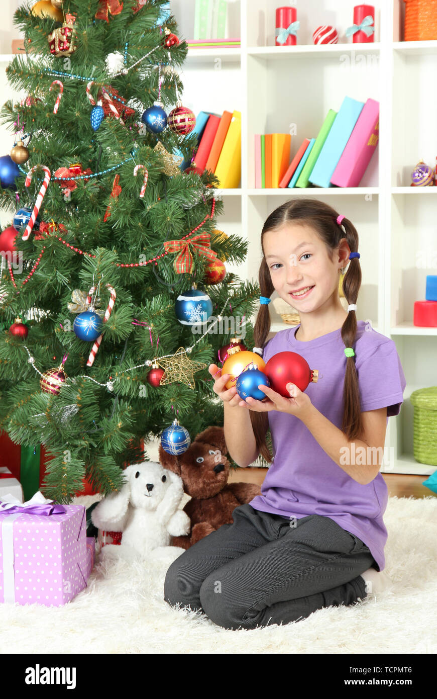 Little girl decorating christmas tree Stock Photo - Alamy