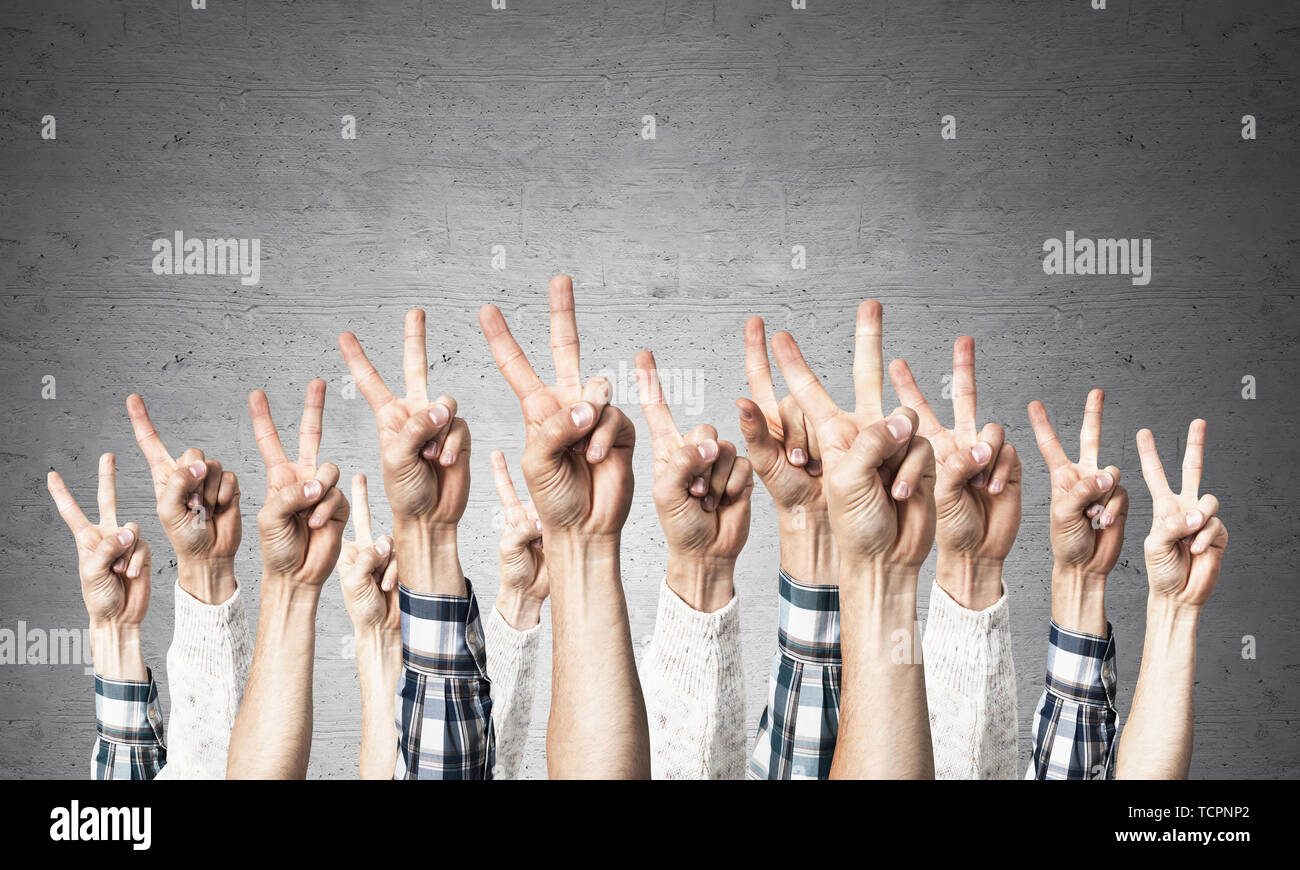 Row of man hands showing victory gesture Stock Photo - Alamy