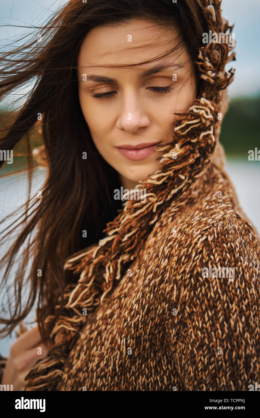 Portrait of beautiful young woman posing at the river in the city on ...
