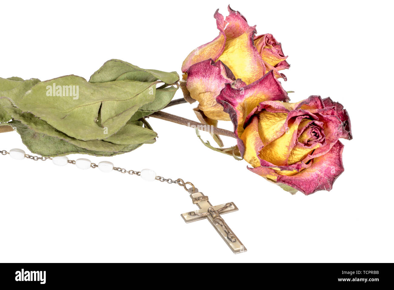 Christian cross on rosary and a dry yellow red rose isolated on white ...
