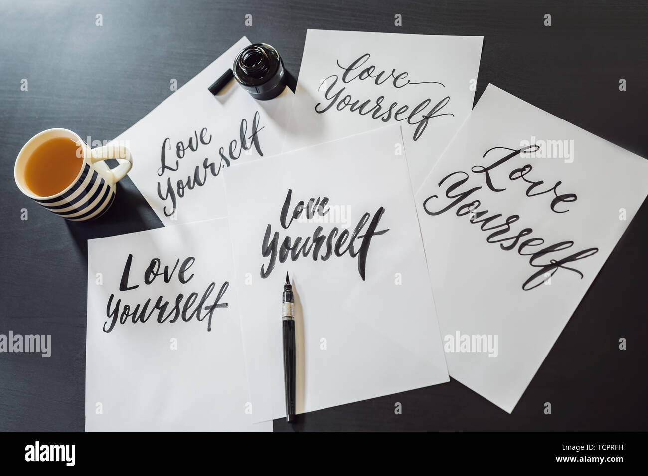 Love yourself. Calligrapher Young Woman writes phrase on white paper ...