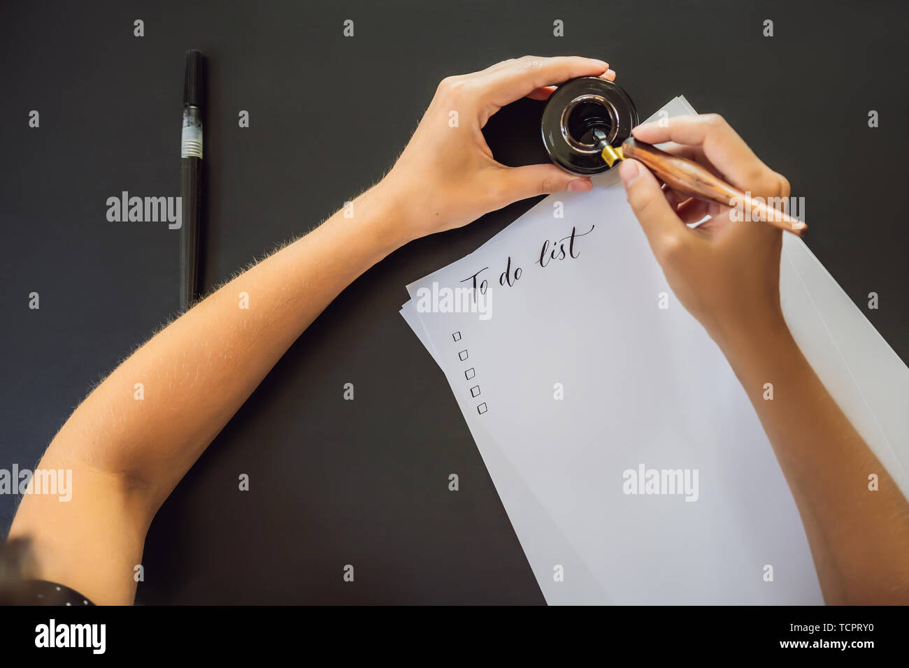 To do list. Calligrapher Young Woman writes phrase on white paper ...